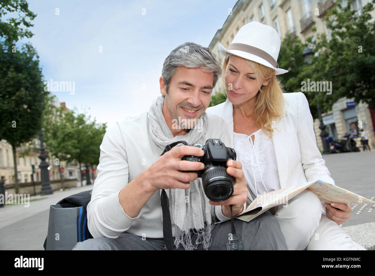 Happy tourists looking at pictures on camera screen Stock Photo - Alamy