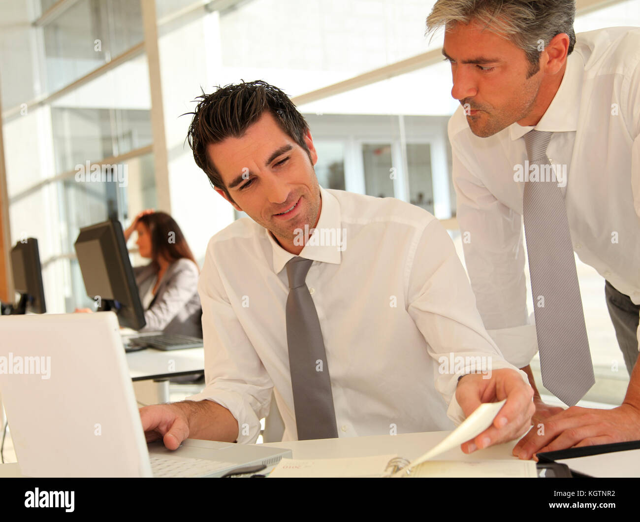 Businessmen working together on laptop computer Stock Photo - Alamy