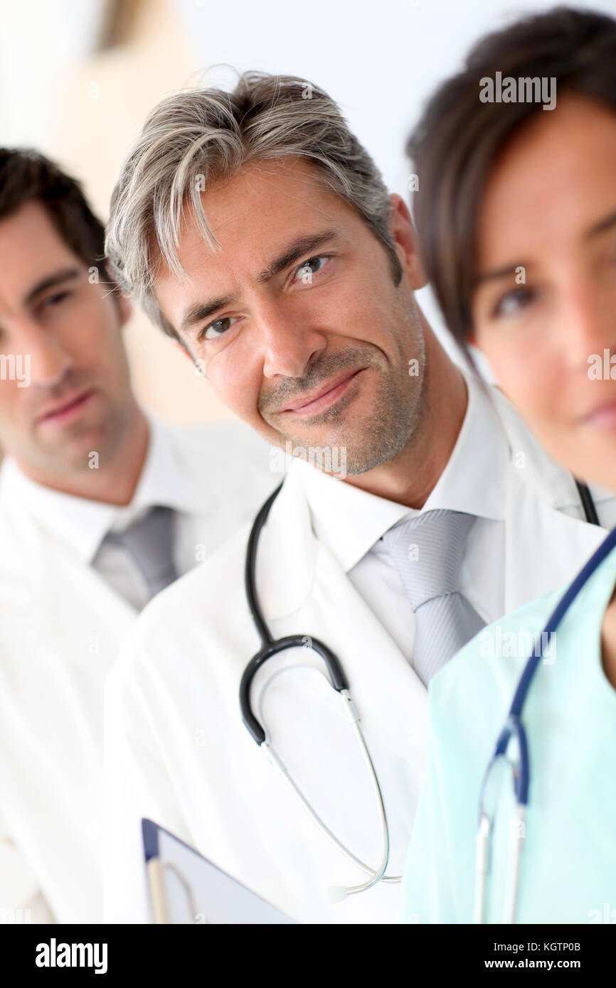 Portrait of doctor standing amongst medical team Stock Photo - Alamy
