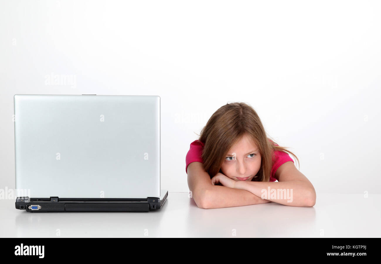 Girl with thoughtful look next to laptop computer Stock Photo - Alamy