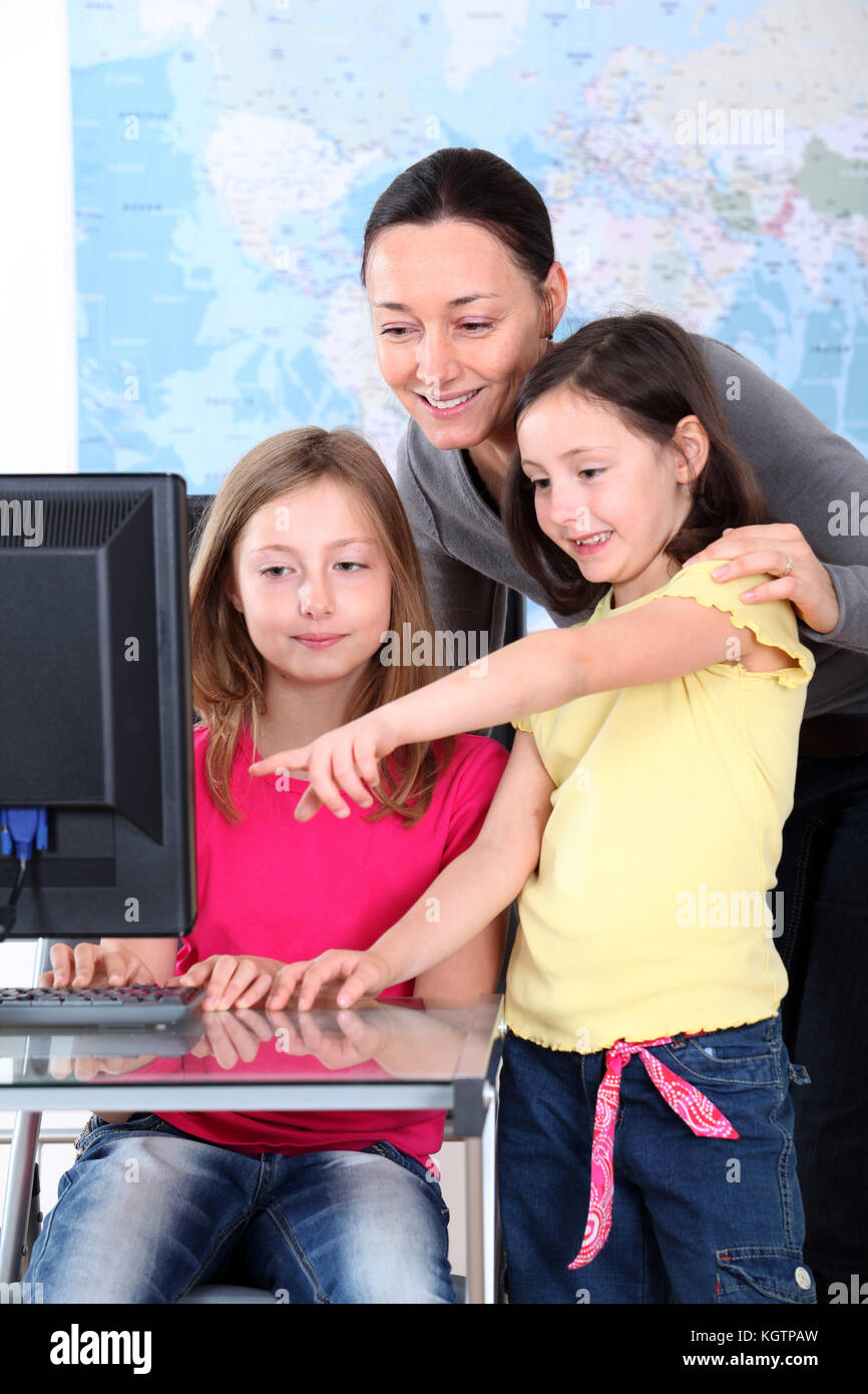 Teacher with kids in front of desktop computer Stock Photo - Alamy