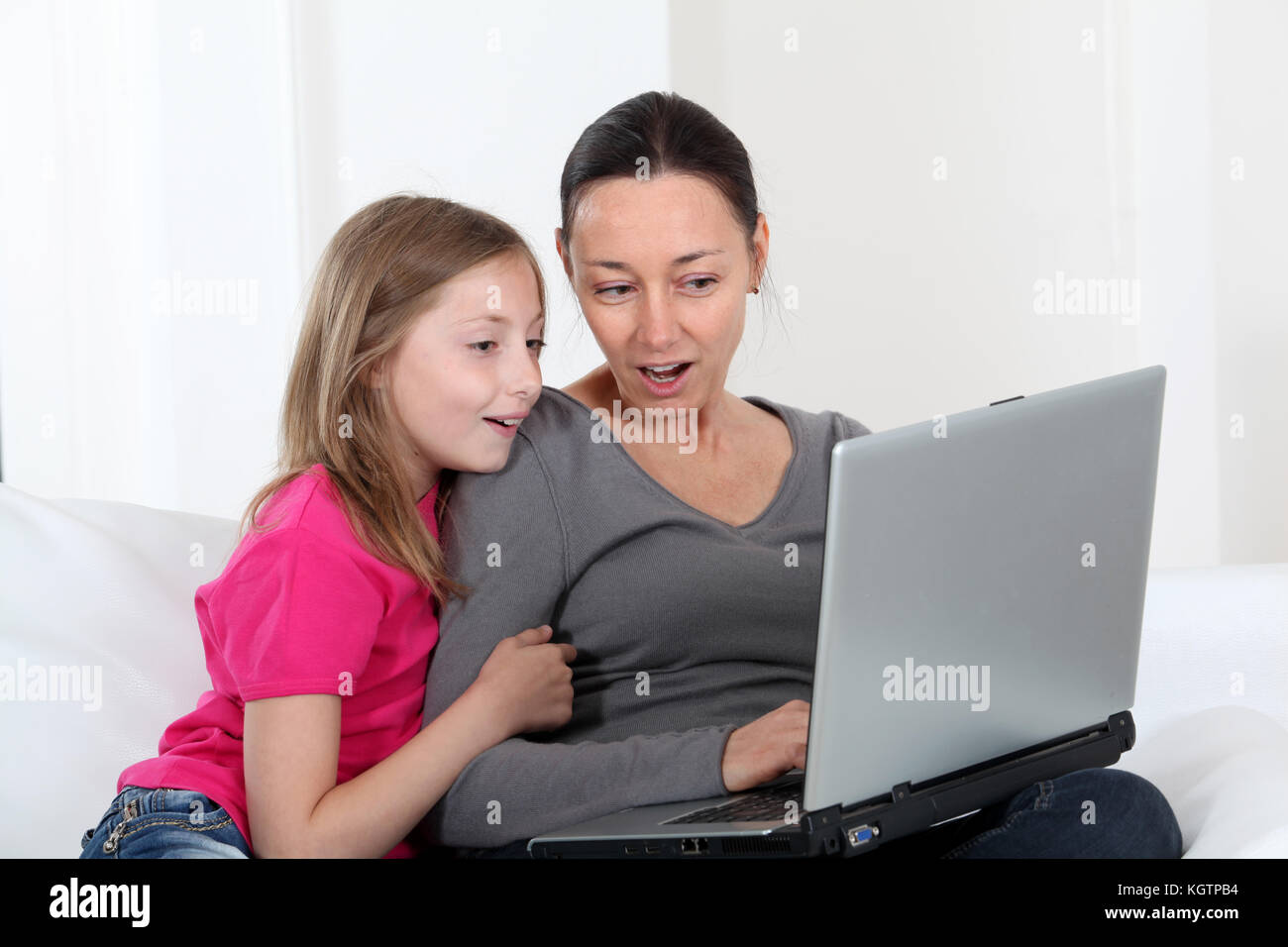 Mother and daughter using laptop computer at home Stock Photo - Alamy