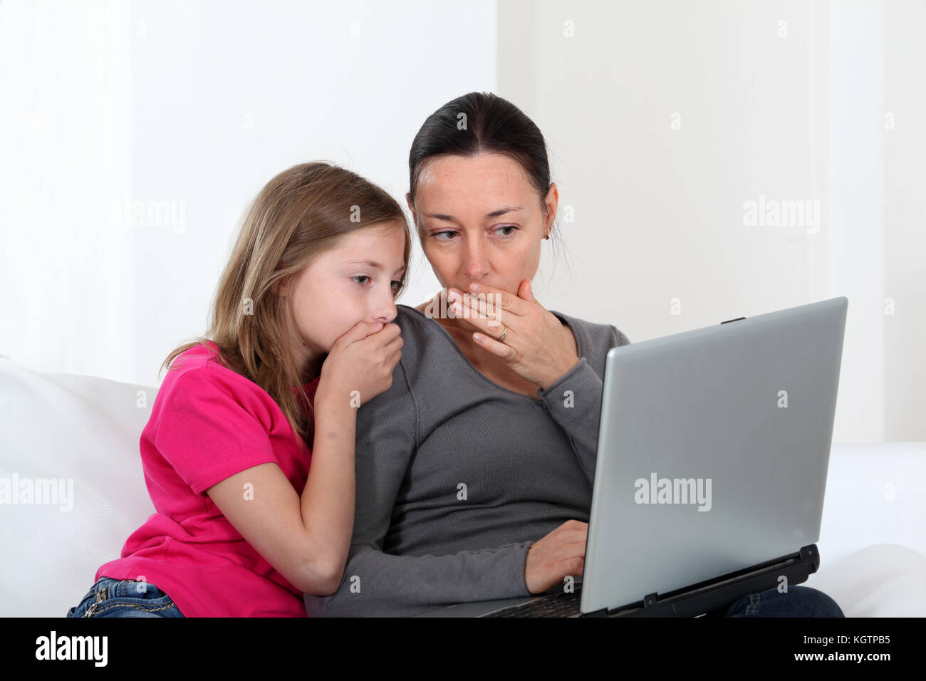Mother and daughter using laptop computer at home Stock Photo - Alamy
