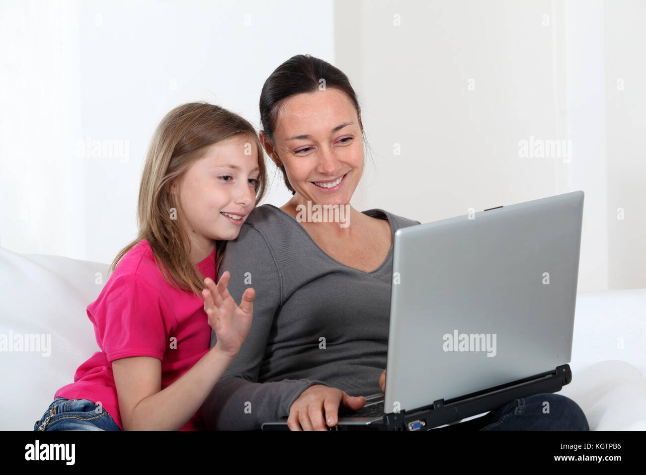 Mother and daughter using laptop computer at home Stock Photo - Alamy