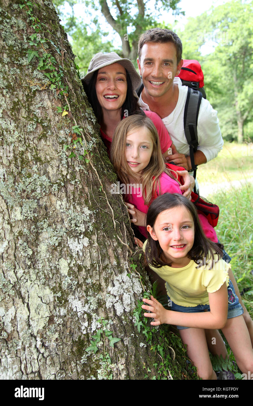 Portrait of happy family standing by a tree Stock Photo - Alamy