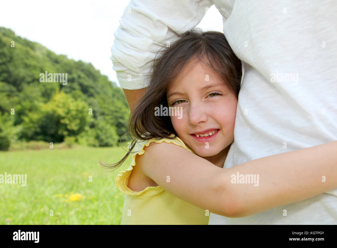 Little girl putting her arms around her father's waist Stock Photo - Alamy
