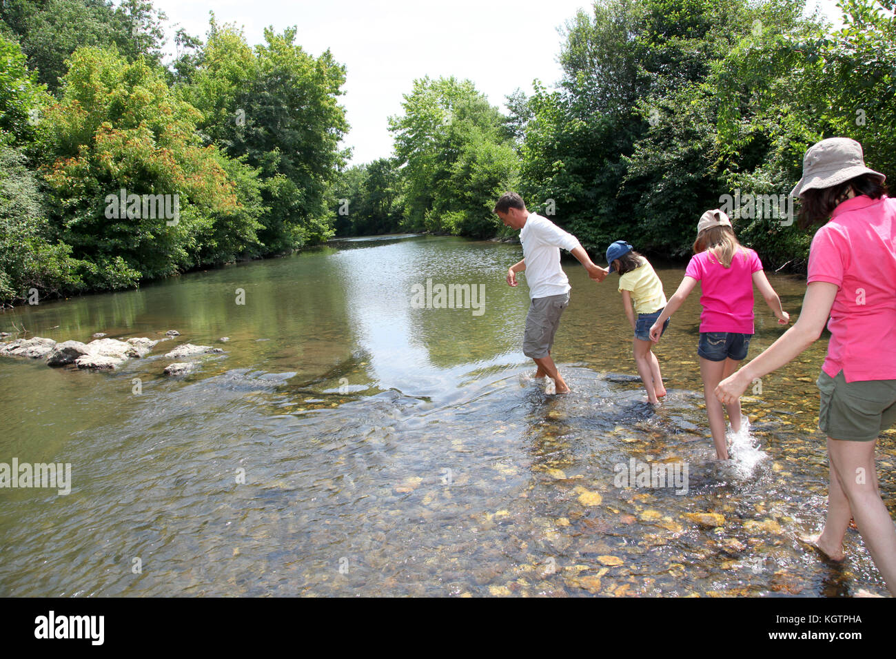 Family crossing river in summer Stock Photo - Alamy