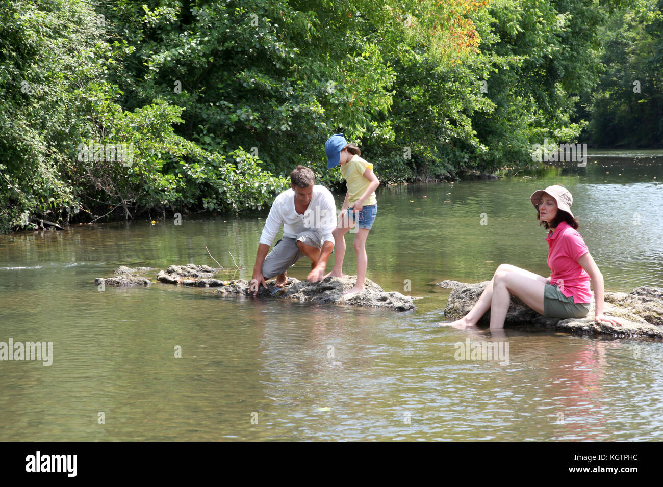 Family sitting in river in summer Stock Photo - Alamy