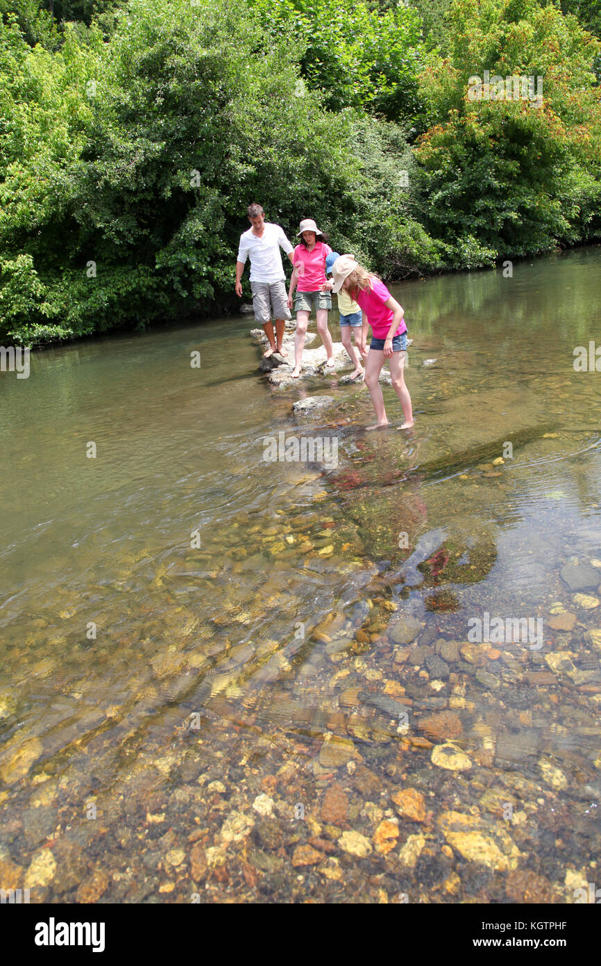 Family crossing river in summer Stock Photo - Alamy