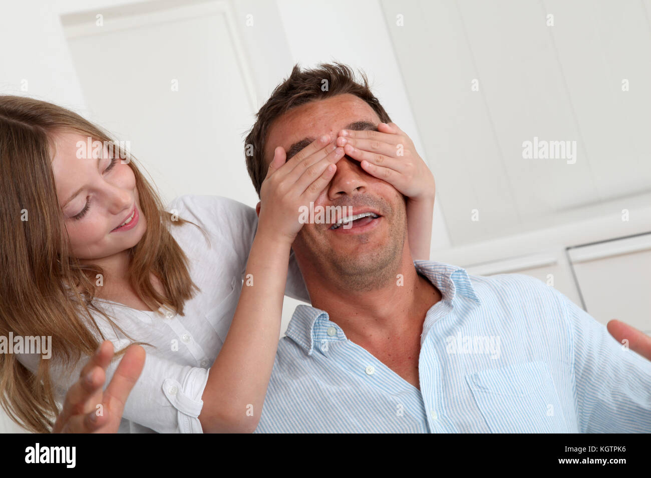 Girl hiding her father's eyes Stock Photo - Alamy
