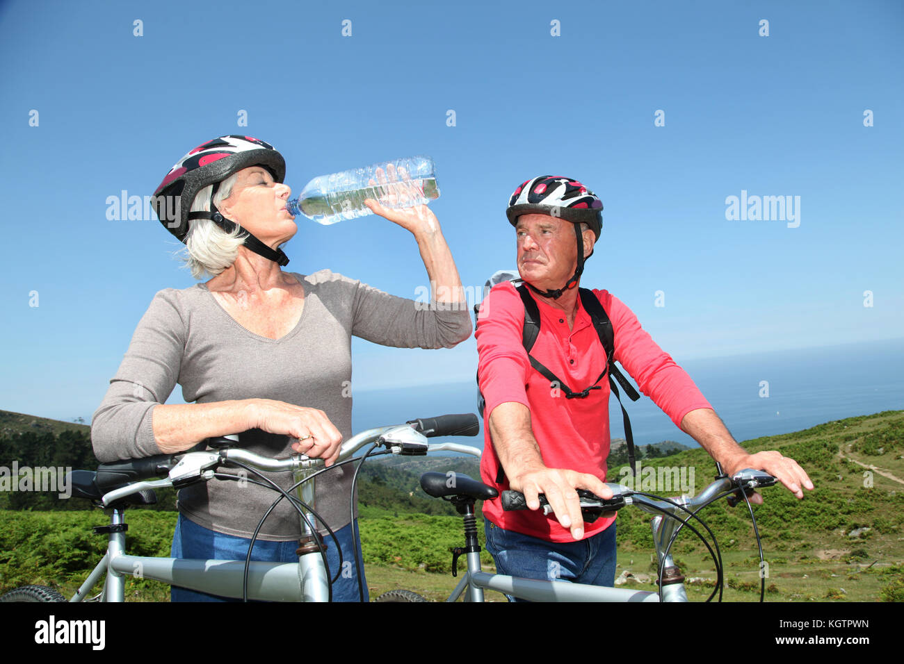 Senior couple drinking water during bike ride Stock Photo - Alamy