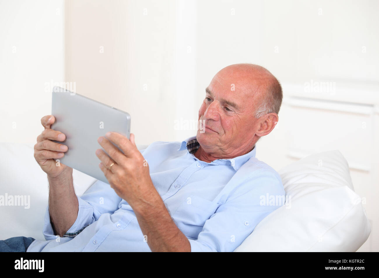 Senior man using electronic tablet at home Stock Photo - Alamy