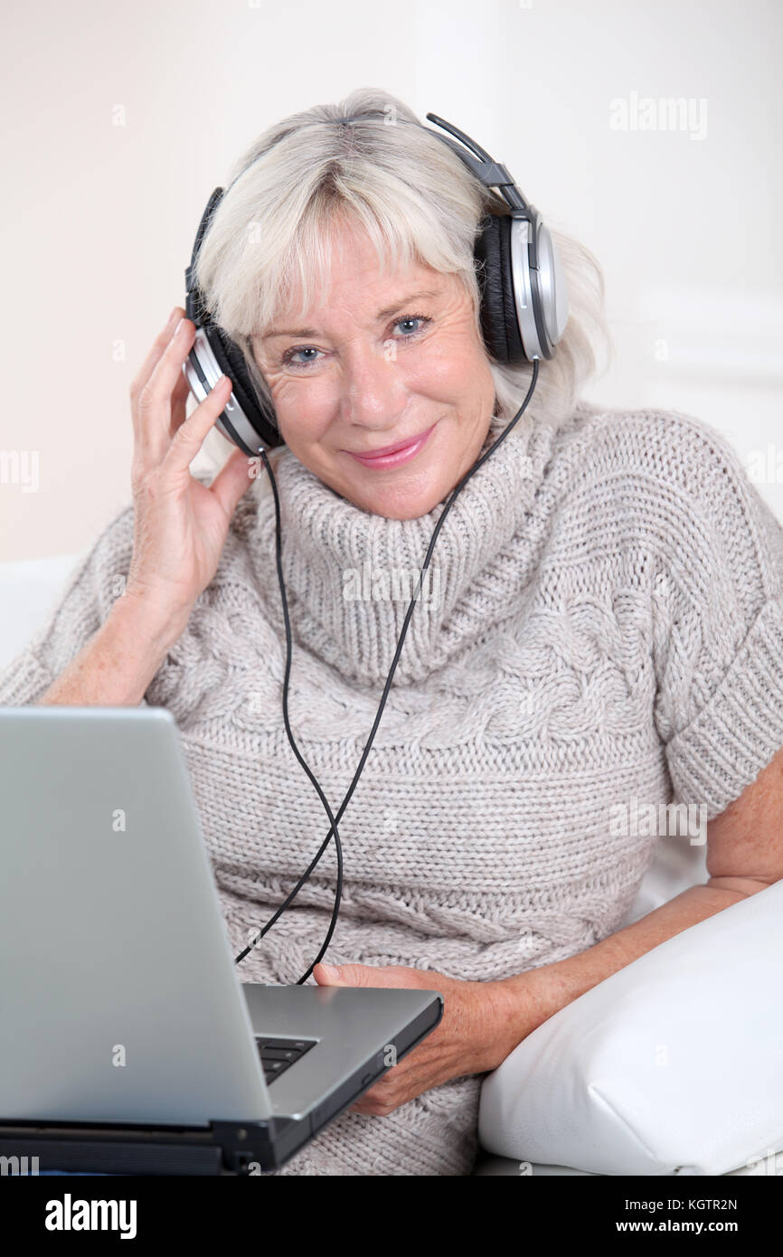 Senior woman listening to music with headphones Stock Photo - Alamy