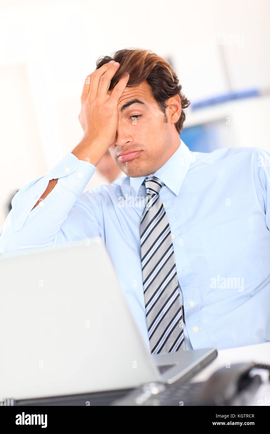 Businessman with tired look at work Stock Photo - Alamy