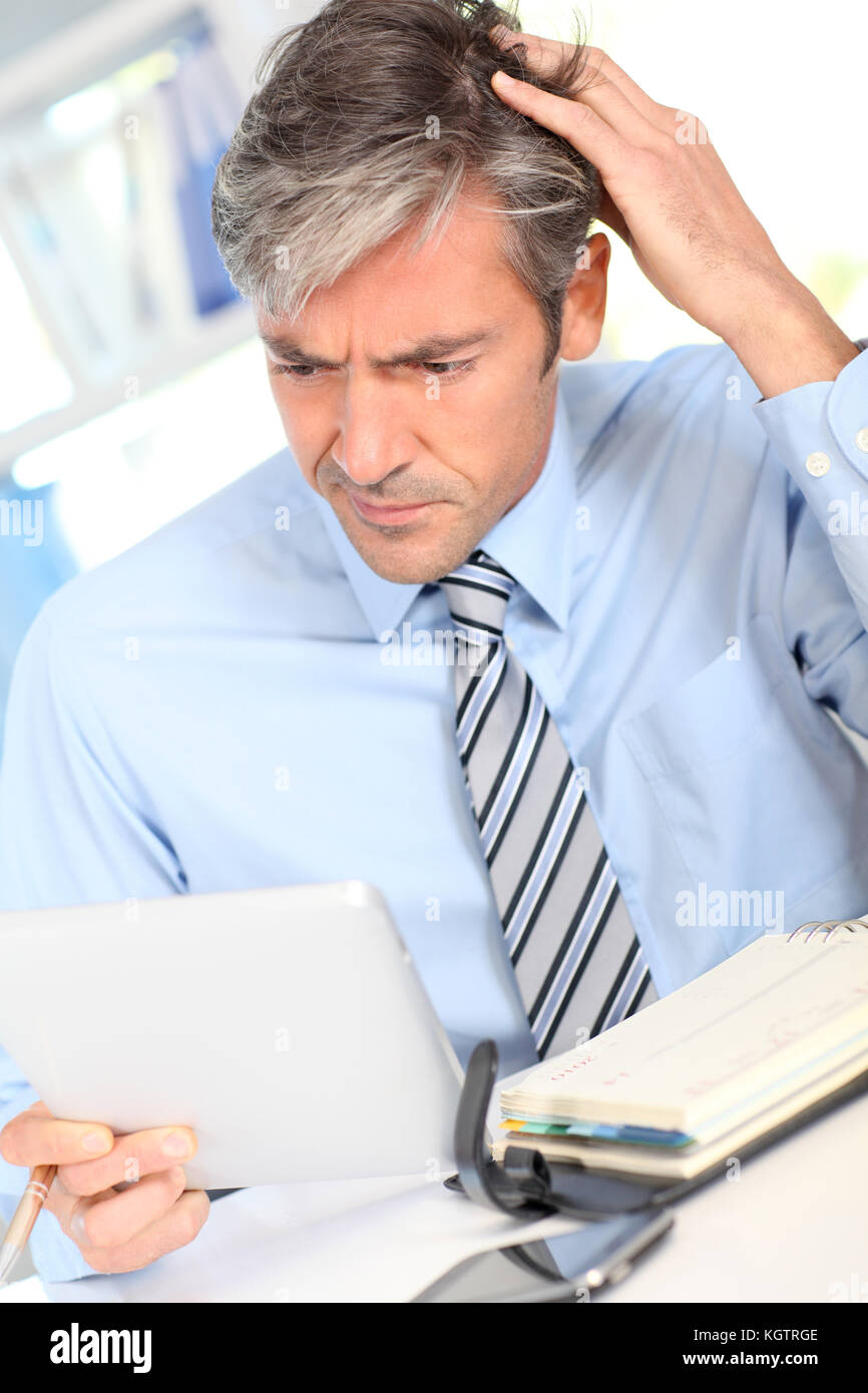 Manager in office using electronic tablet Stock Photo - Alamy