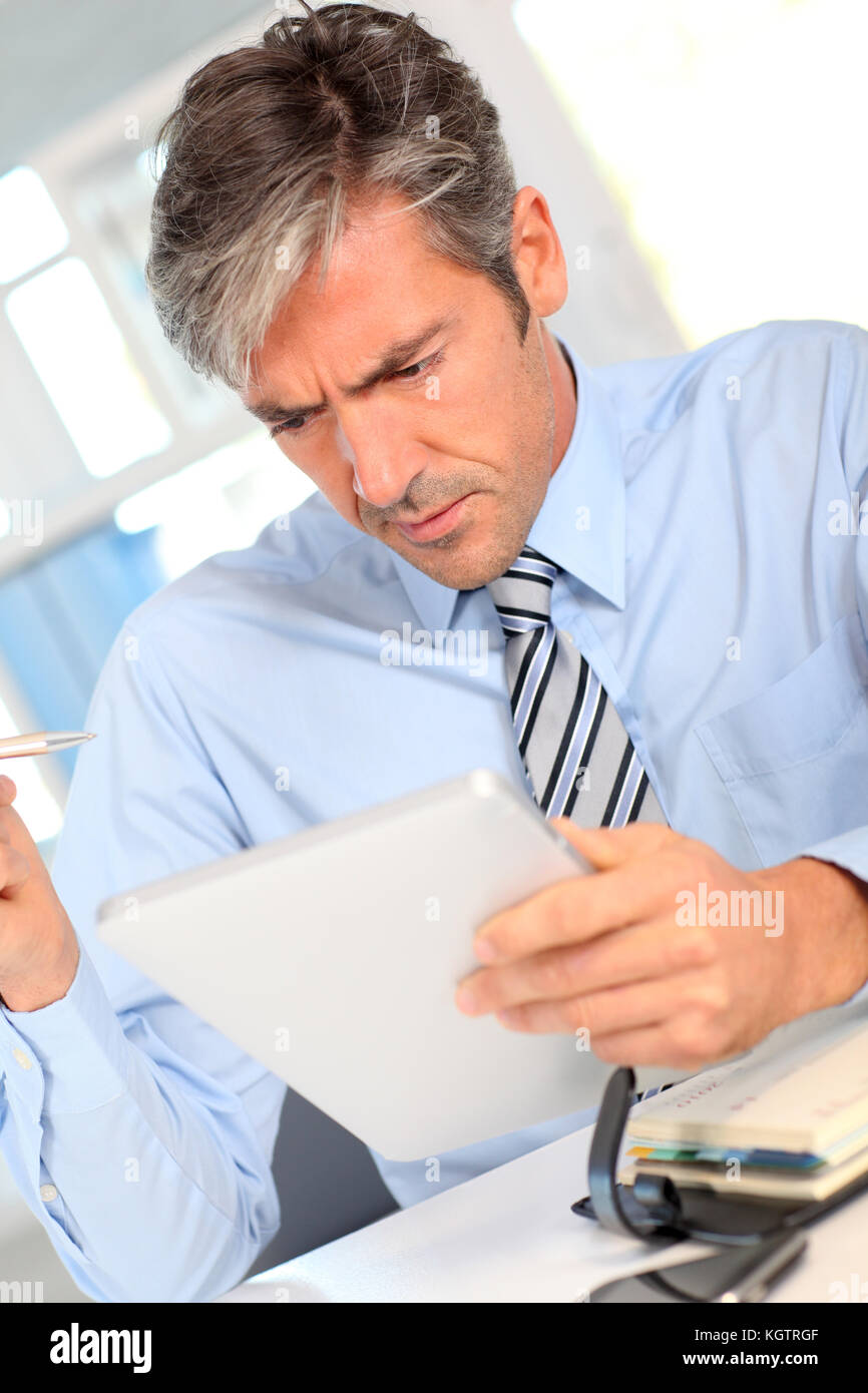 Manager in office using electronic tablet Stock Photo - Alamy