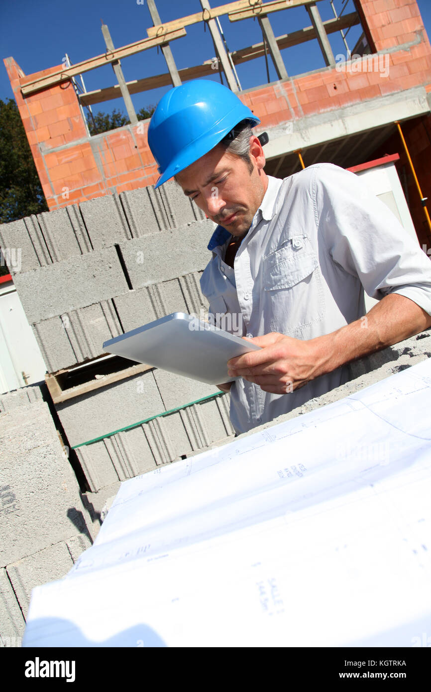 Construction manager using electronic tablet on building site Stock ...
