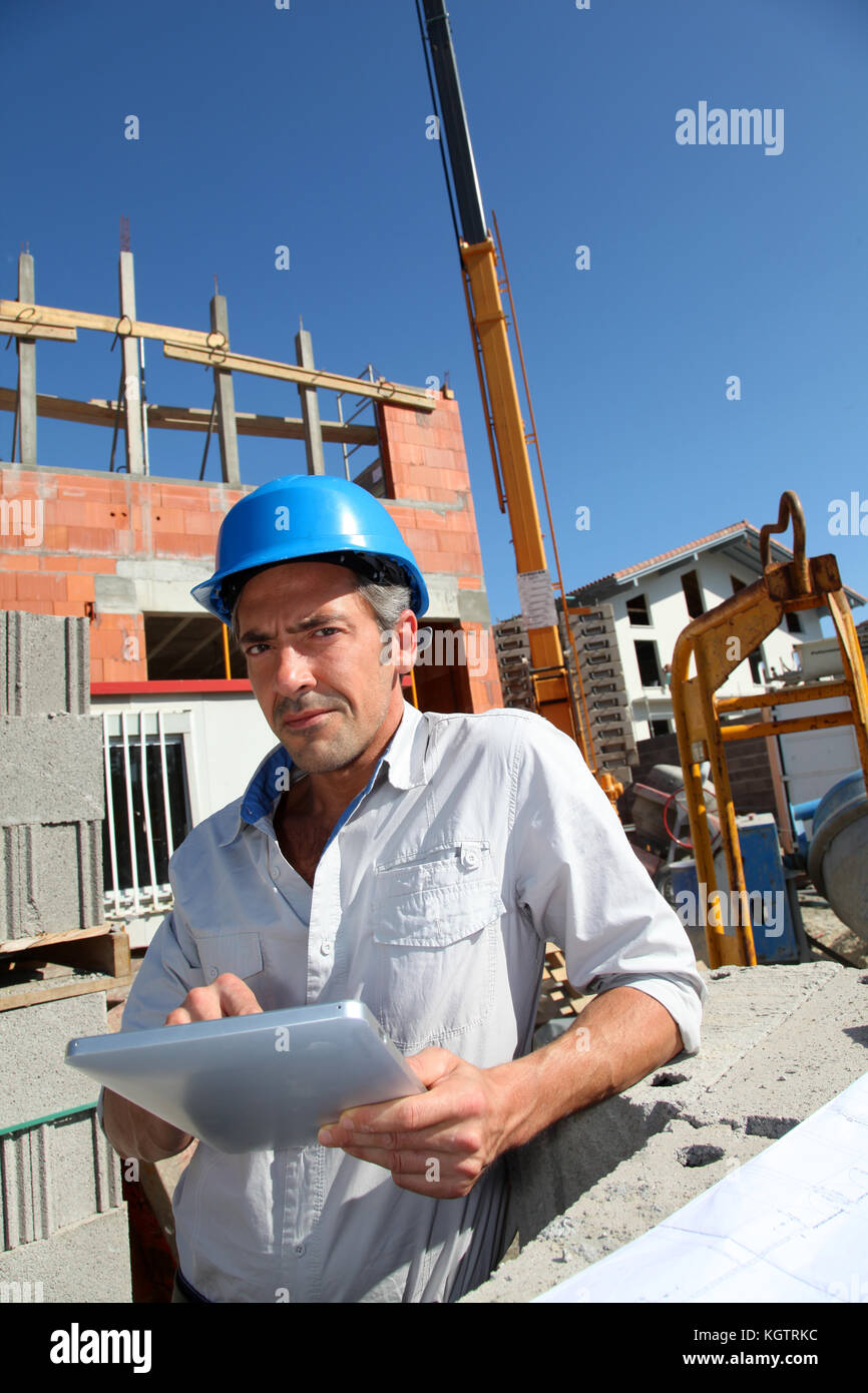 Construction manager using electronic tablet on building site Stock ...