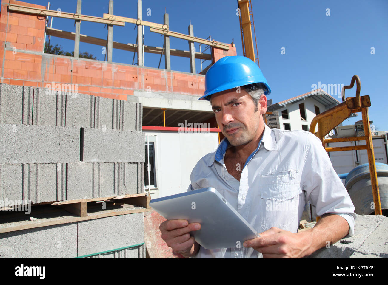 Construction manager using electronic tablet on building site Stock ...
