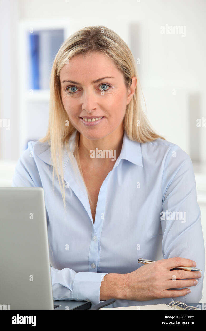 Beautiful blond woman working in the office Stock Photo - Alamy