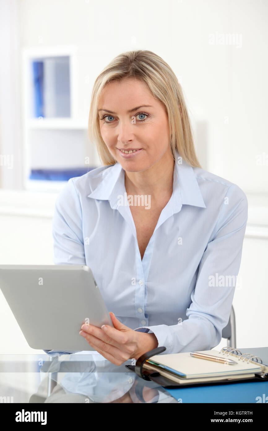 Portrait of office worker using electronic tablet in office Stock Photo ...