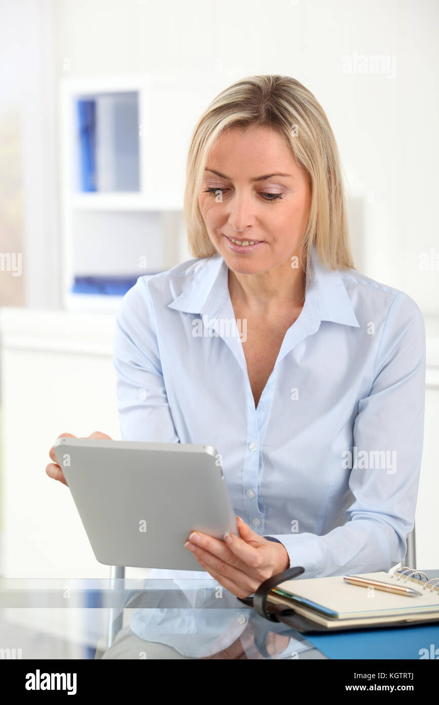 Portrait of office worker using electronic tablet in office Stock Photo ...