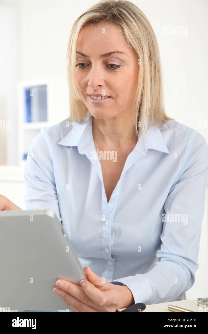 Portrait of office worker using electronic tablet in office Stock Photo ...