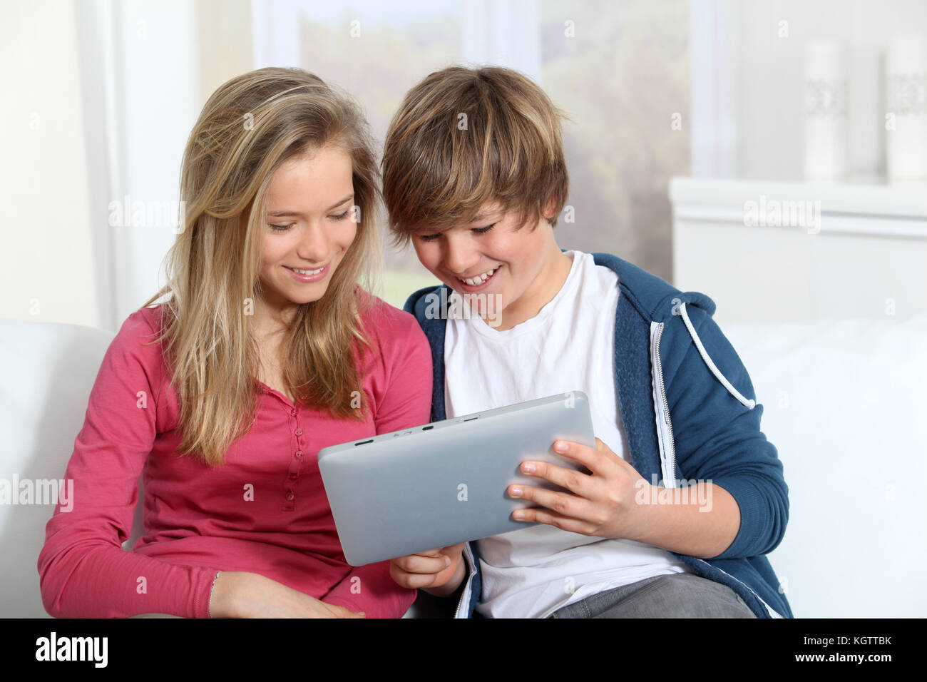 Young teenagers using electronic tablet Stock Photo - Alamy