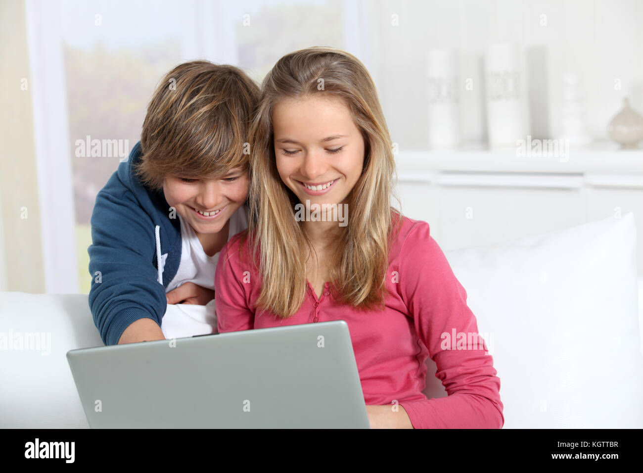 Brother and sister using laptop computer at home Stock Photo - Alamy