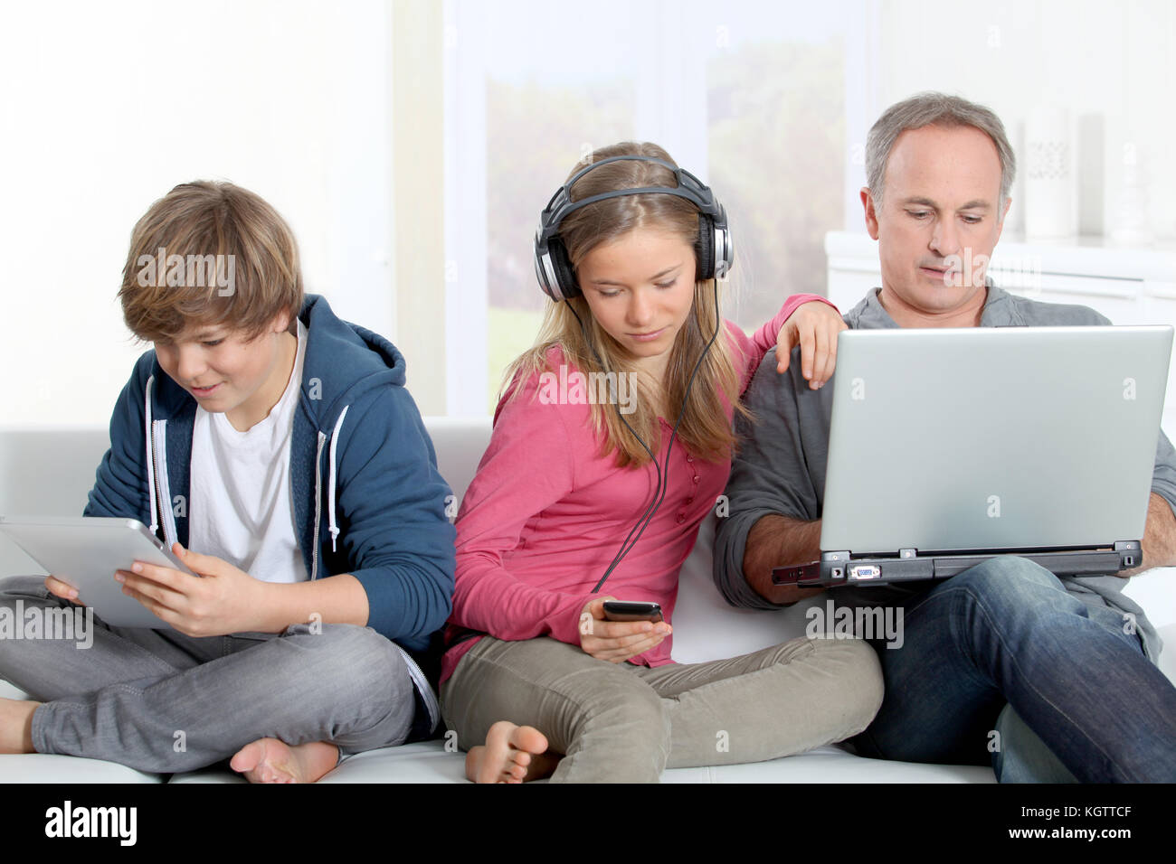 Father and children using electronic devices at home Stock Photo - Alamy