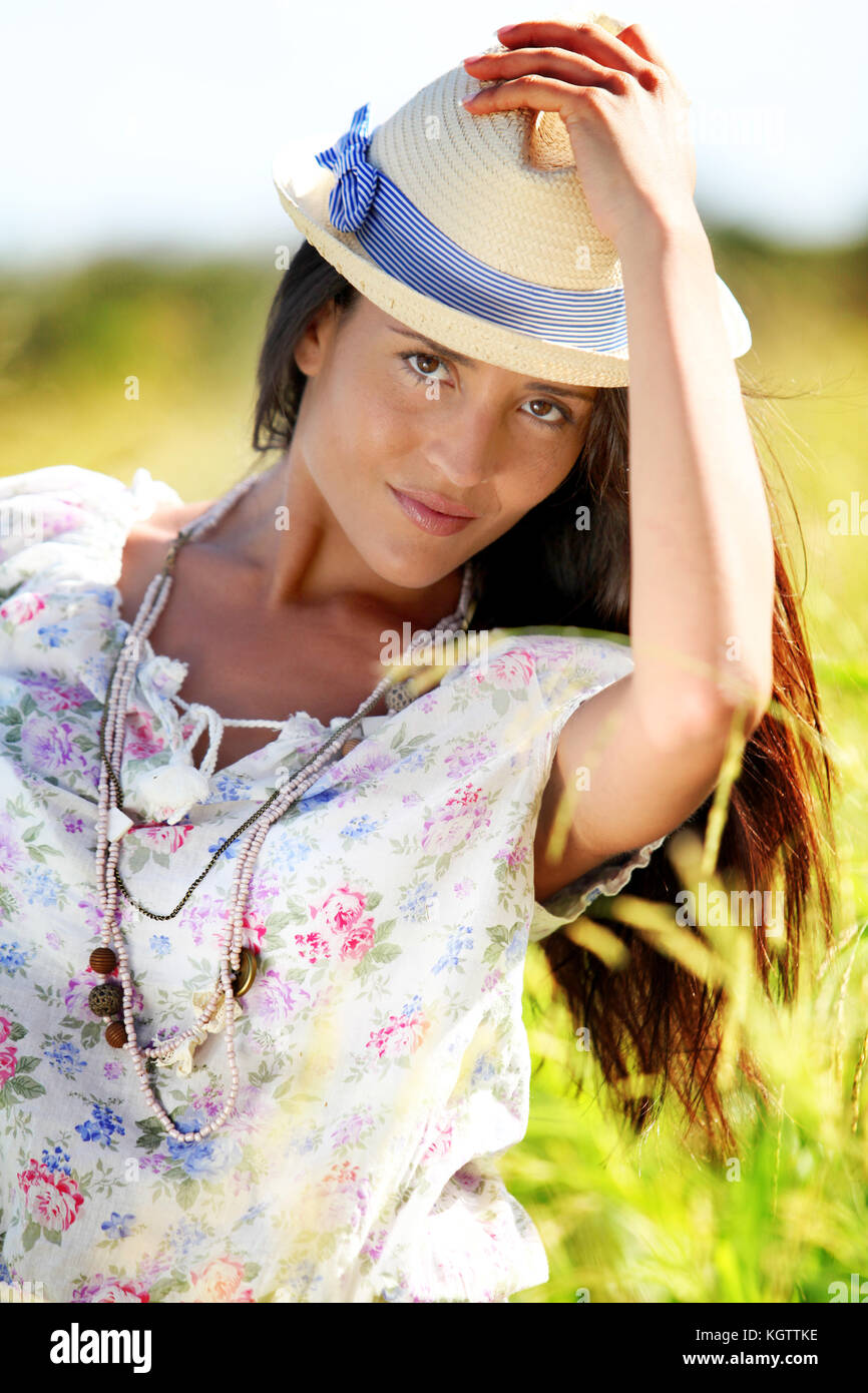 Gypsy girl with hat standing in field of wild flowers Stock Photo - Alamy