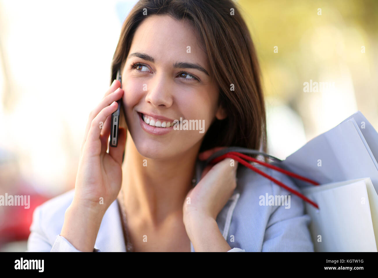 Attractive shopping girl in town talking on the phone Stock Photo - Alamy