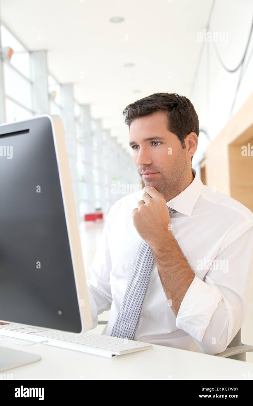 Salesman in front of desktop computer Stock Photo - Alamy