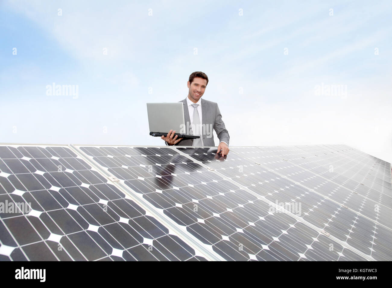 Businessman standing by solar panels Stock Photo - Alamy