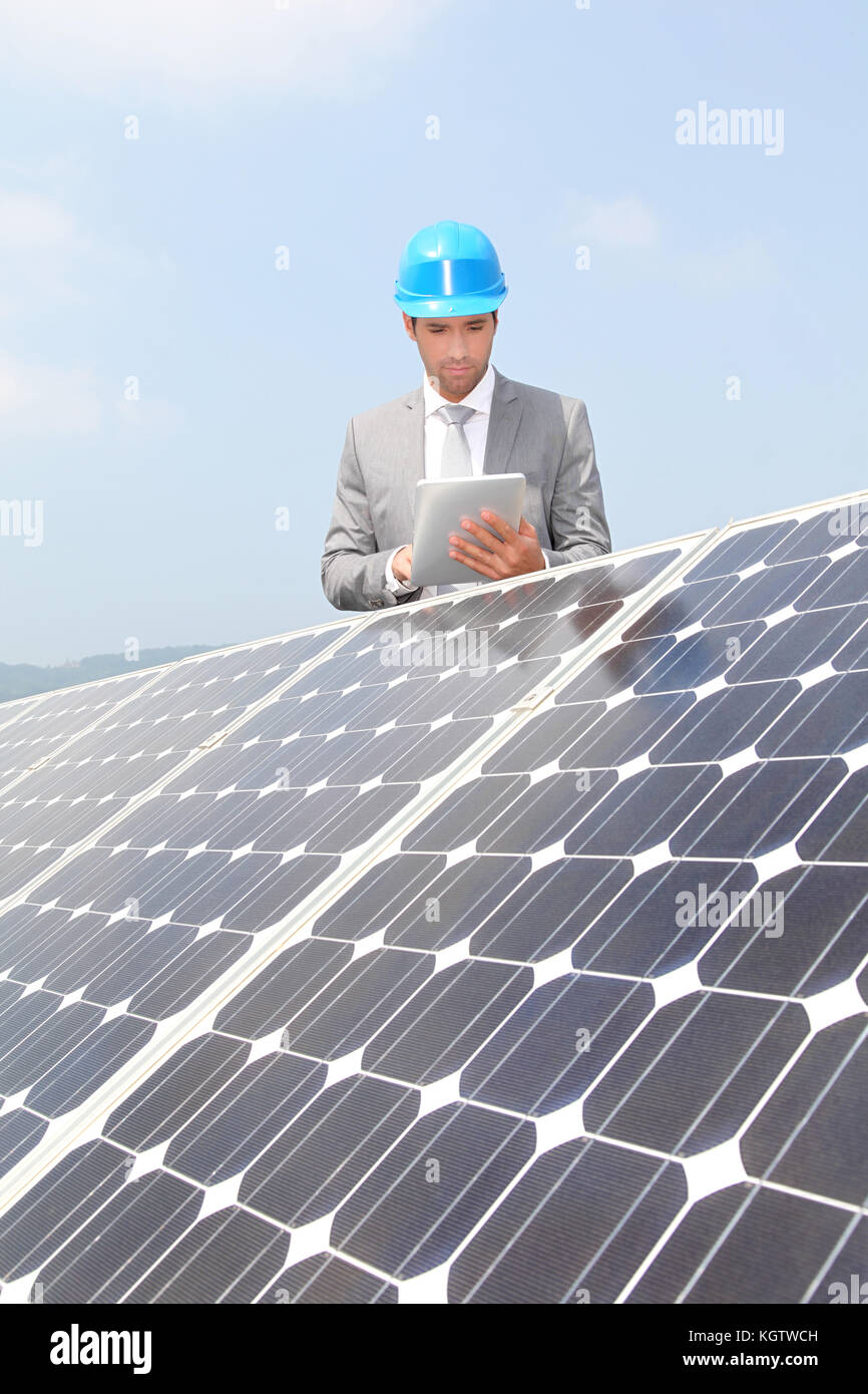 Businessman standing on solar panel installation Stock Photo - Alamy