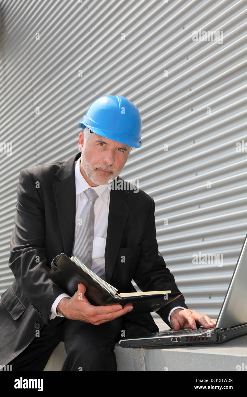 Site manager checking planning on computer Stock Photo - Alamy