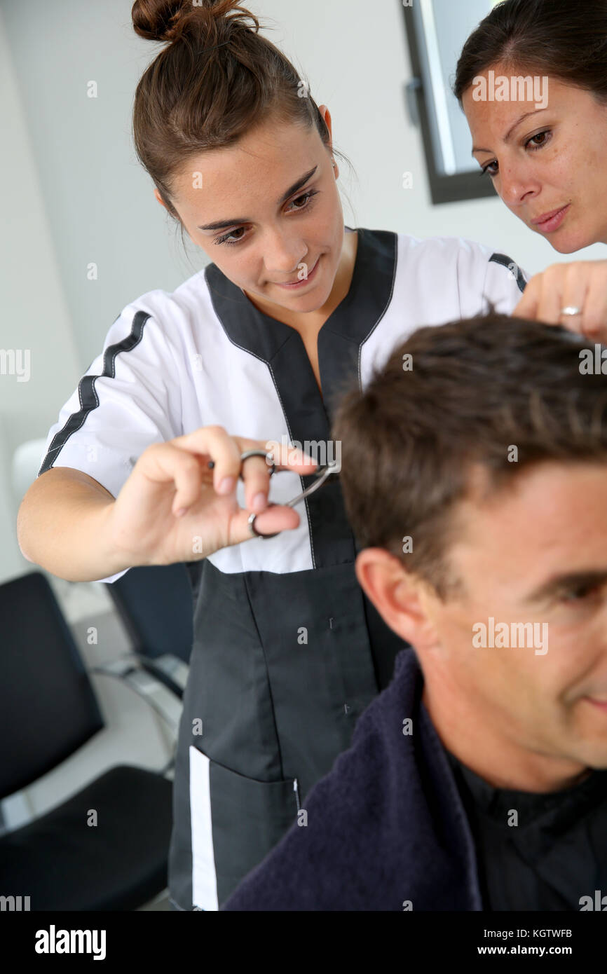 Student girl in hairdressing learning how to cut hair Stock Photo - Alamy