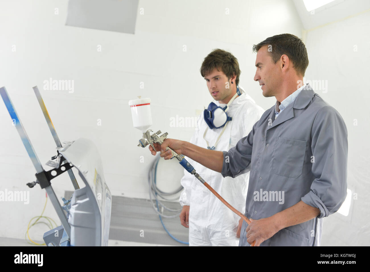 Instructor with teenager in car painting training class Stock Photo - Alamy
