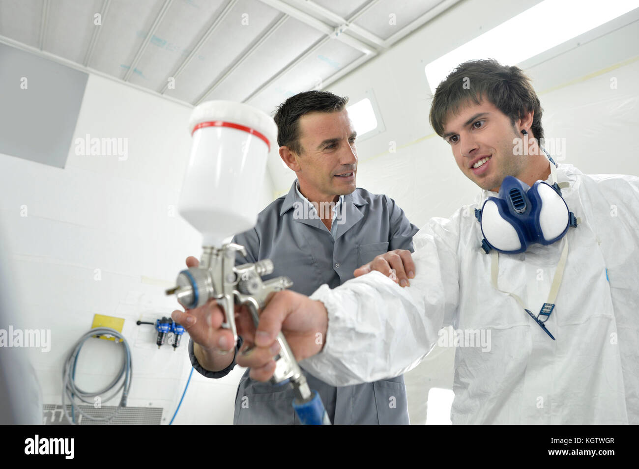 Instructor with teenager in car painting training class Stock Photo - Alamy
