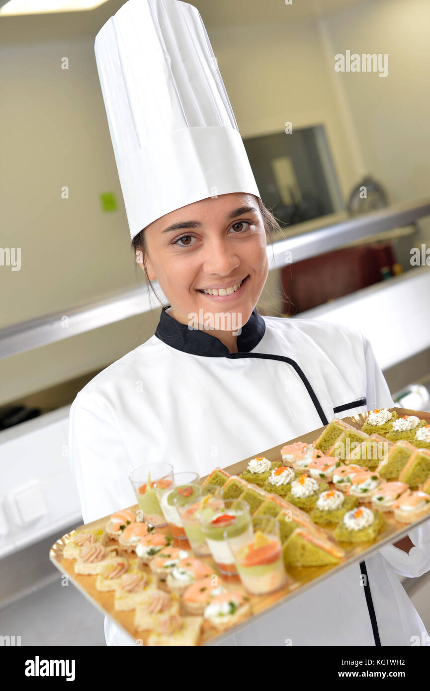 Cheerful young cook holding plate of delicatessen Stock Photo - Alamy