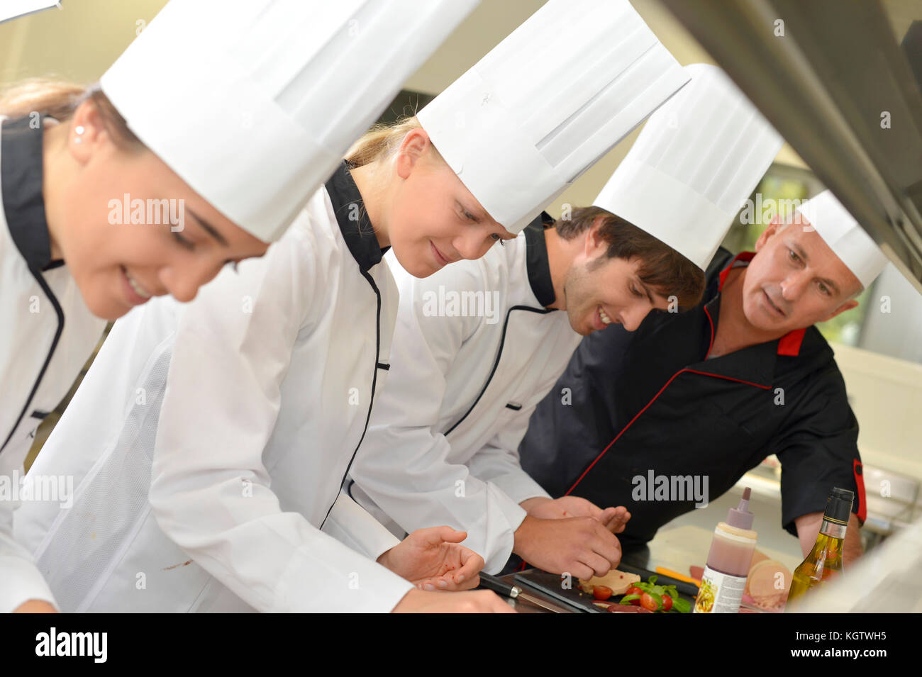 Team of young chefs preparing delicatessen dishes Stock Photo - Alamy