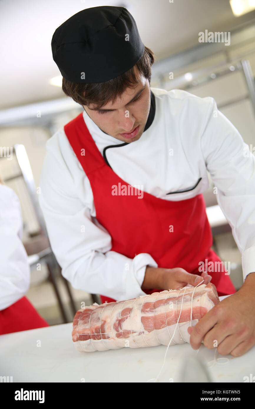 Butcher preparing roast in butchery school kitchen Stock Photo - Alamy