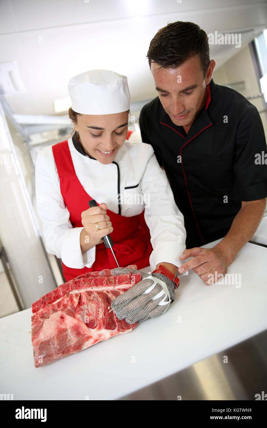 Professional butcher teaching student with meat cutting Stock Photo - Alamy
