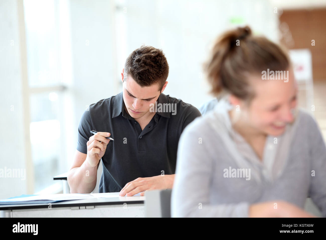 Student in class writing assignment Stock Photo - Alamy