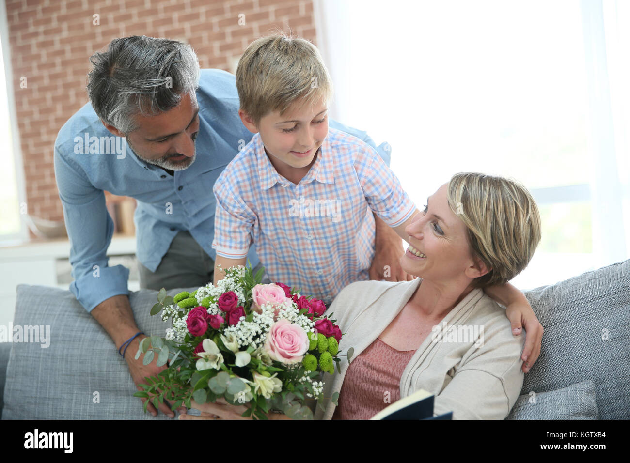 Young boy giving flowers to mommy for mother's day Stock Photo - Alamy