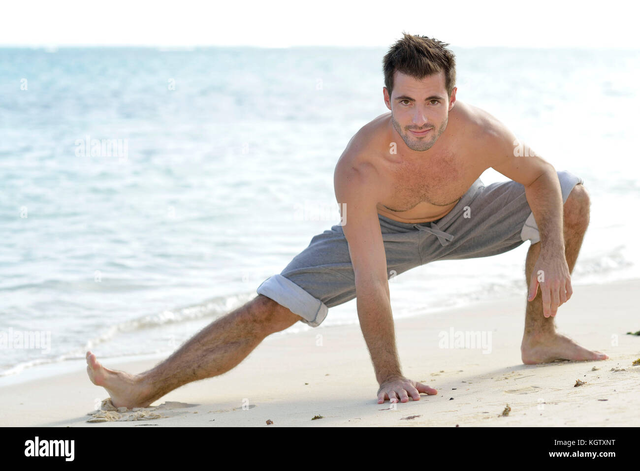 Man stretching on the beach Stock Photo - Alamy