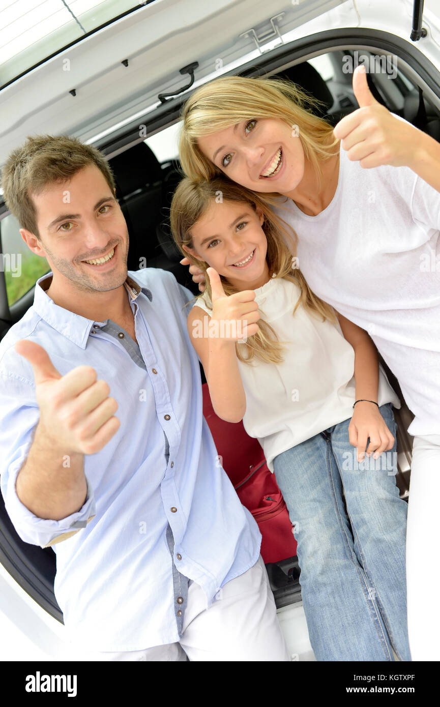 Cheerful family in car trunk showing thumbs up Stock Photo - Alamy