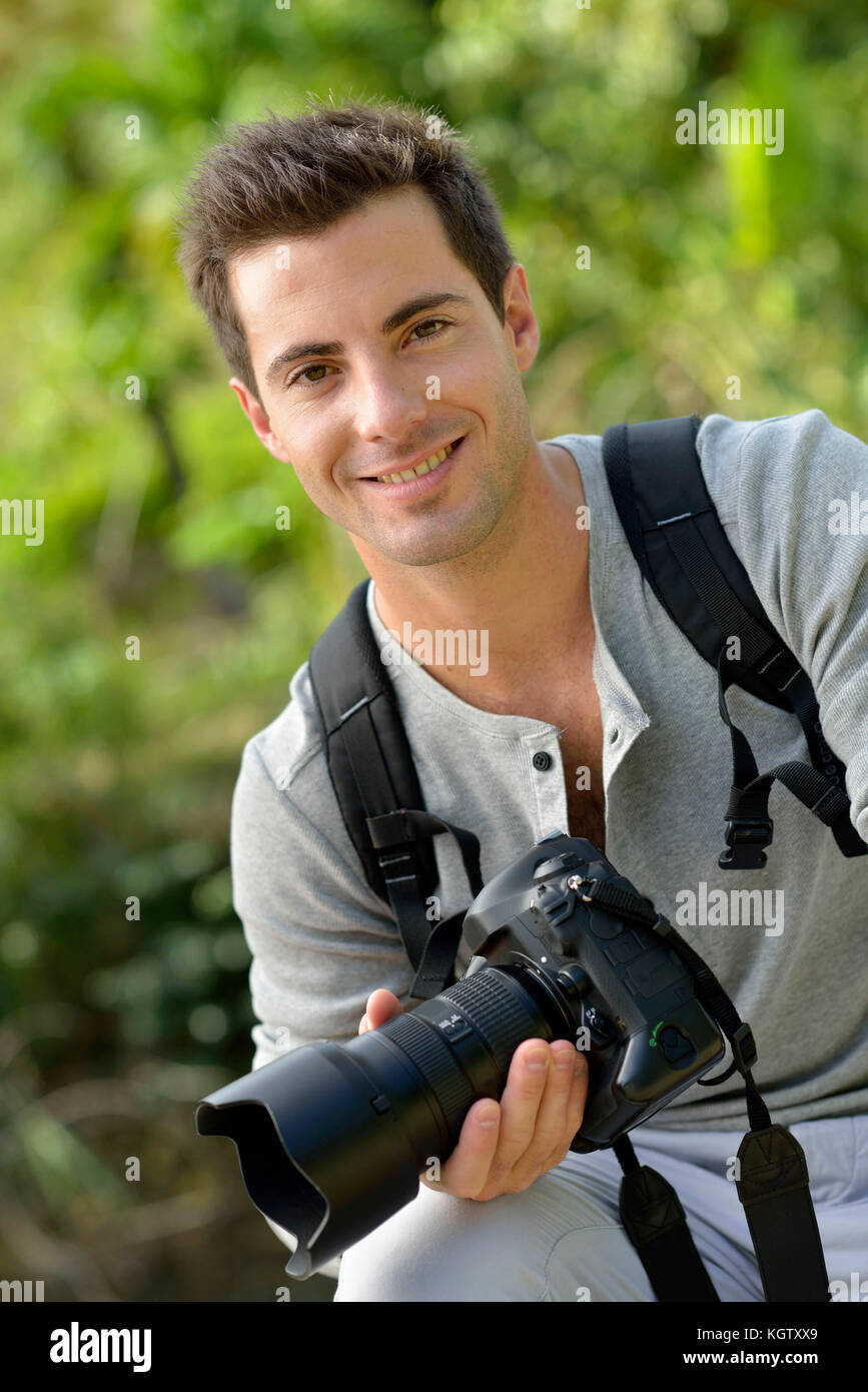 Portrait of young reporter holding photo camera Stock Photo - Alamy