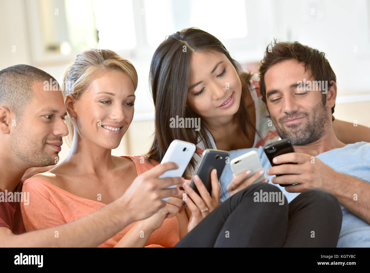 Friends at home playing with smartphones Stock Photo - Alamy