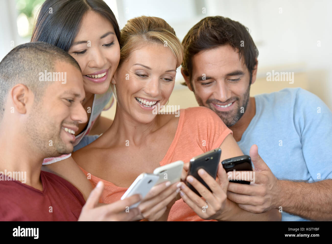 Friends at home playing with smartphones Stock Photo - Alamy